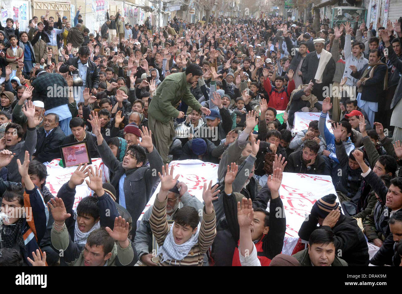 Shiite Muslims sit along with dead bodies that were killed in suicide ...