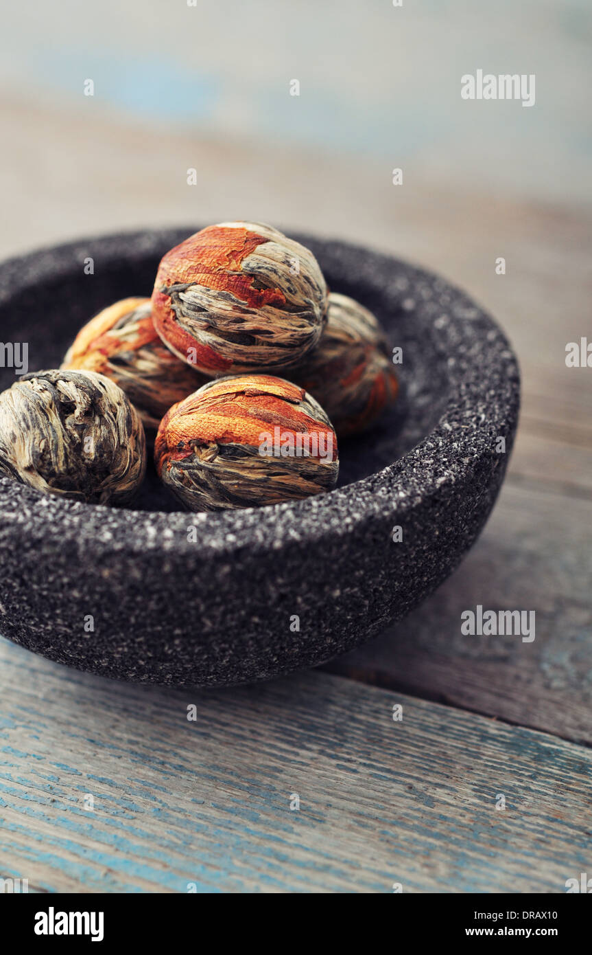 Chinese Green Tea Balls with Lychee Flower in stone bowl on wooden ...