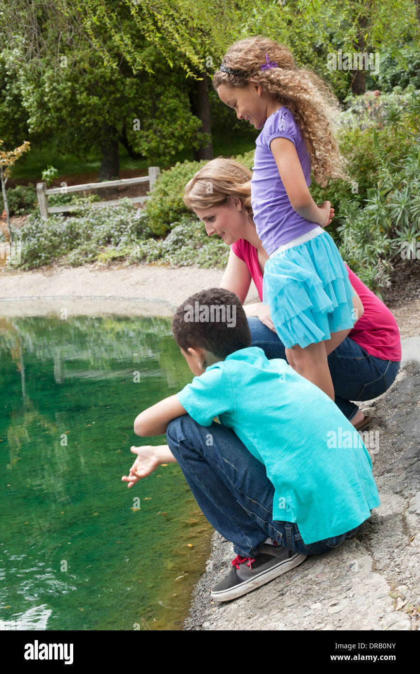 Curious mother with children at riverbank Stock Photo - Alamy