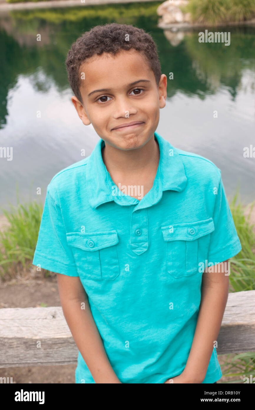Portrait of a boy smiling in front of river Stock Photo - Alamy