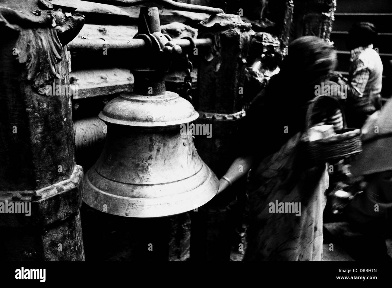 Indian woman ringing temple bell Black and White Stock Photos & Images ...