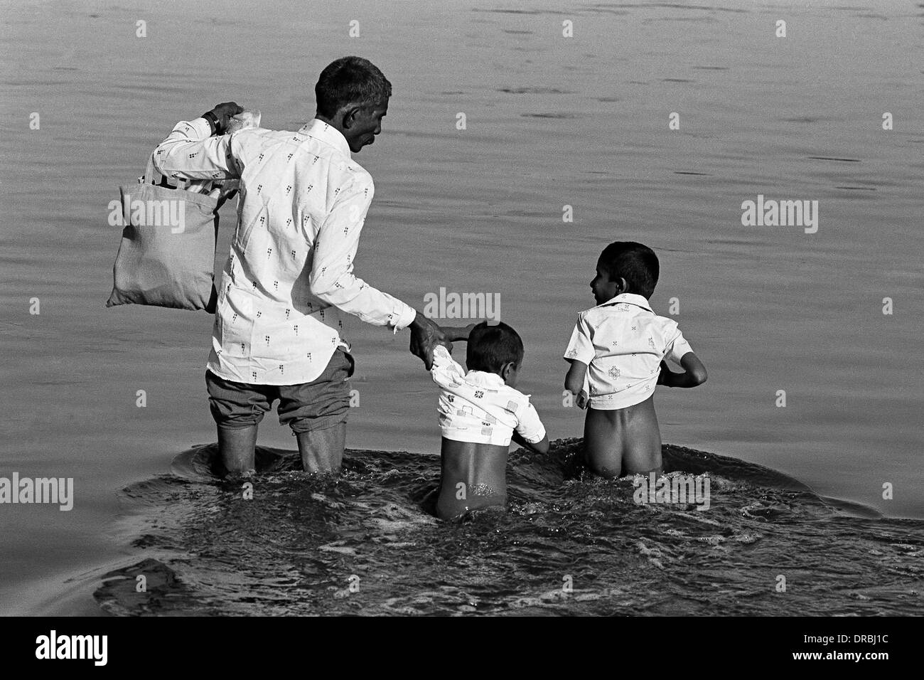 Father and sons crossing Sabarmati river, Vautha fair, Gujarat, India ...
