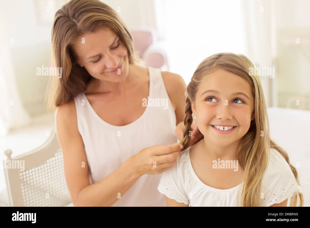 Mother braiding daughter's hair Stock Photo - Alamy