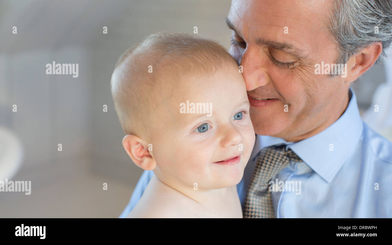 Smiling father holding baby Stock Photo - Alamy