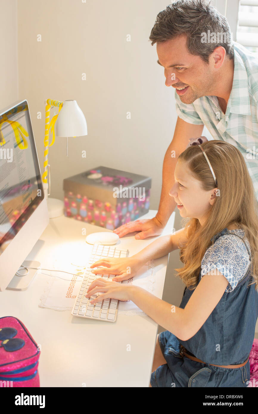 Father and daughter using computer together Stock Photo - Alamy