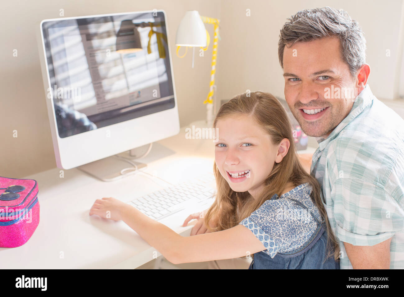 Father and daughter using computer together Stock Photo - Alamy