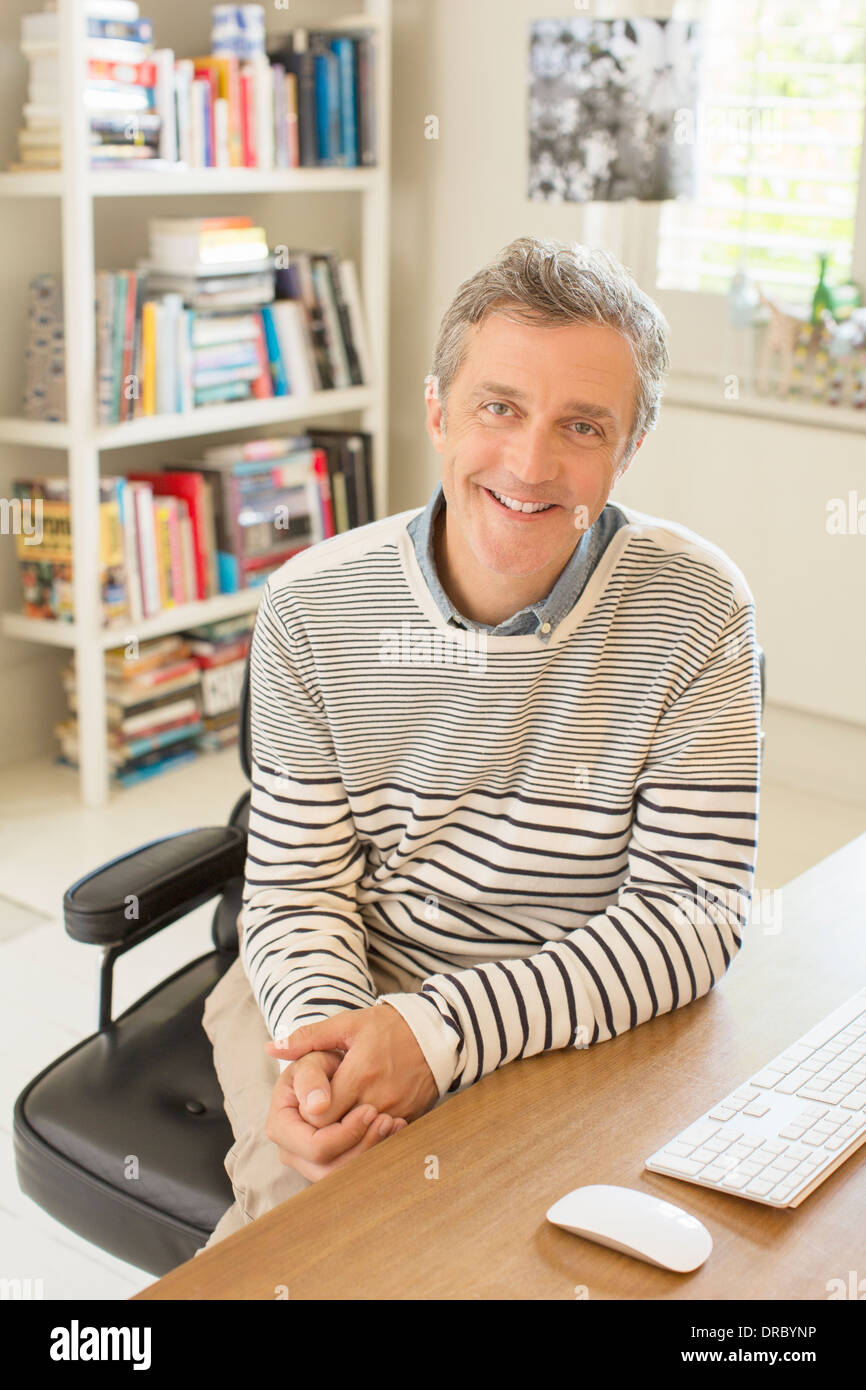 Man smiling at computer desk Stock Photo - Alamy