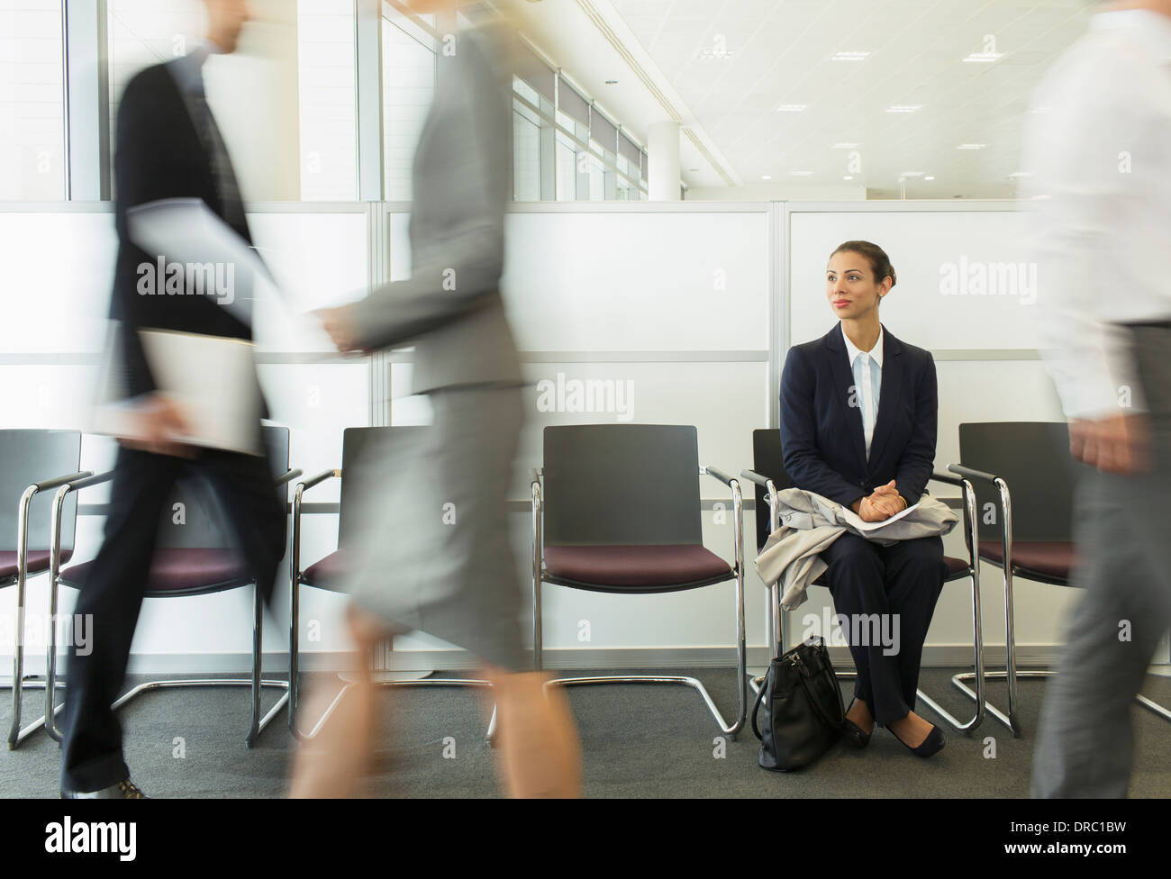 Businesswoman sitting in busy waiting area Stock Photo - Alamy