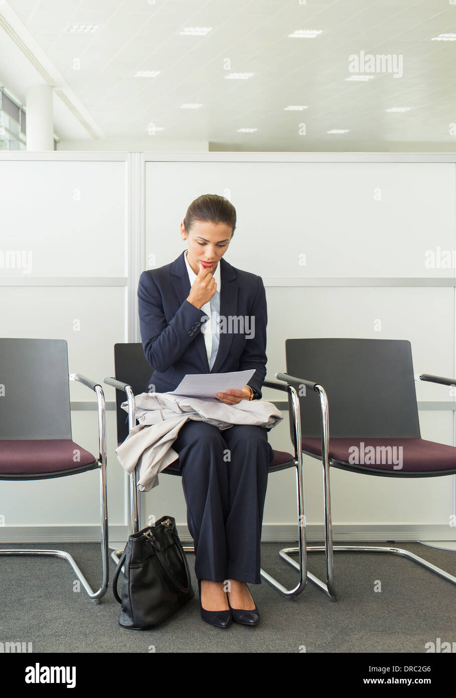Businesswoman reading in waiting area Stock Photo - Alamy