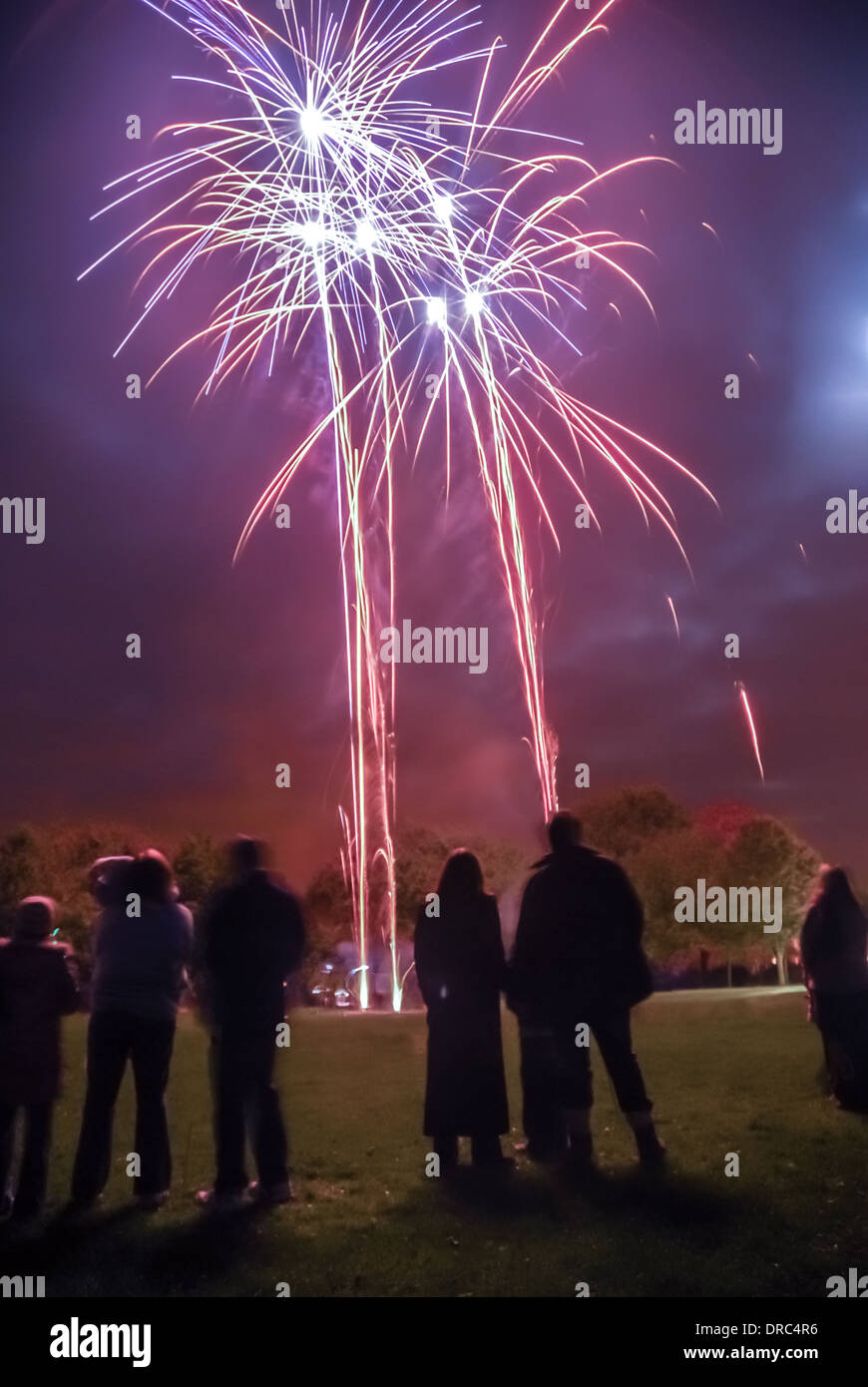An abstract and colorful image of fireworks exploding with people ...
