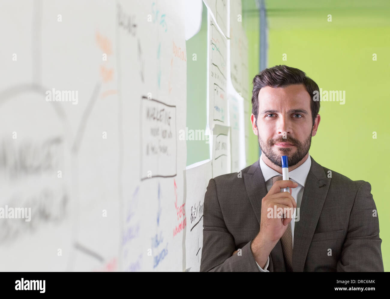 Businessman thinking at glass wall Stock Photo - Alamy