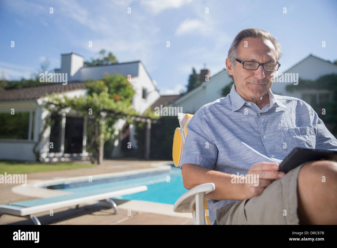 Man sitting by swimming pool hi-res stock photography and images - Alamy