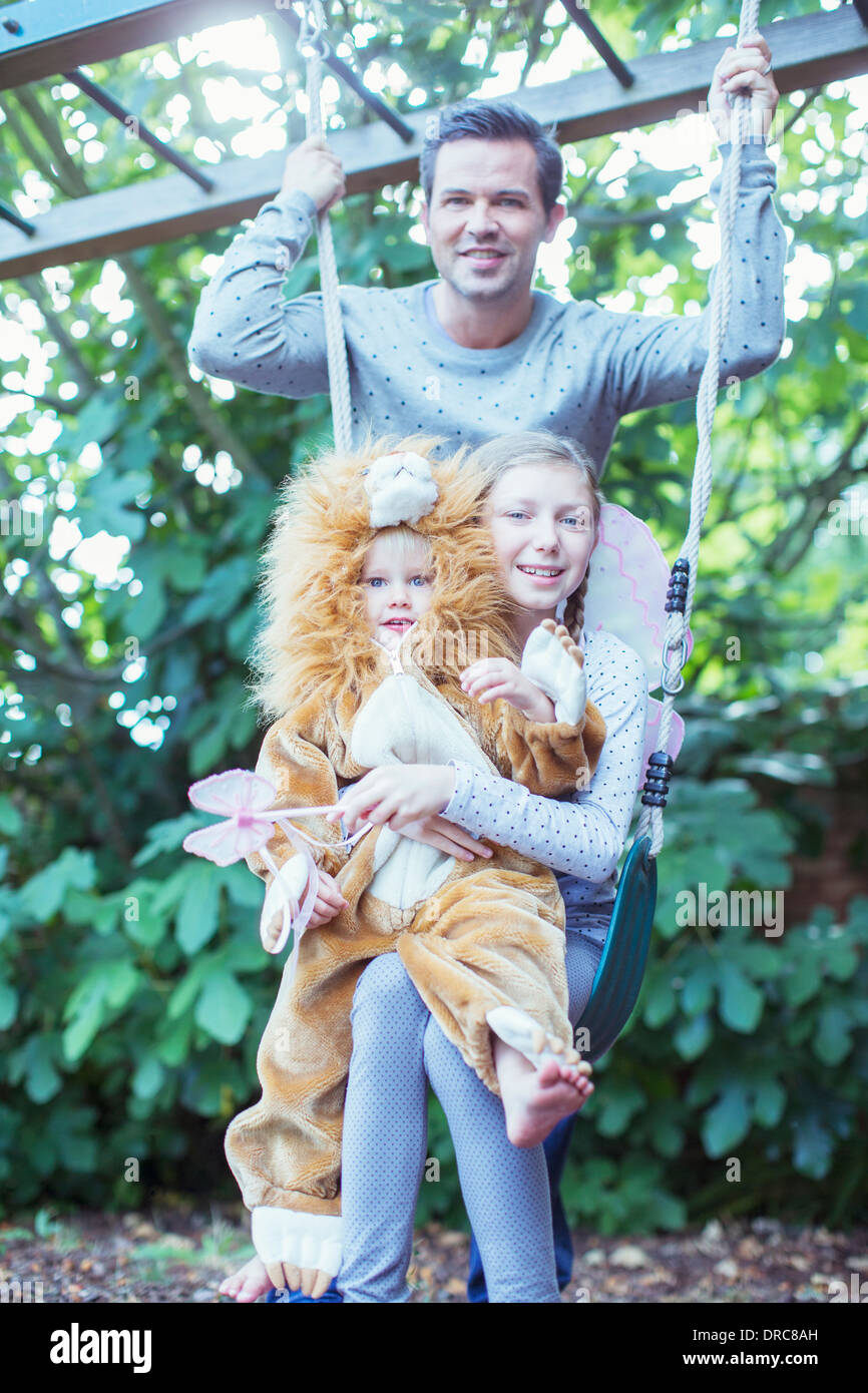 Father and children playing together on swing Stock Photo - Alamy