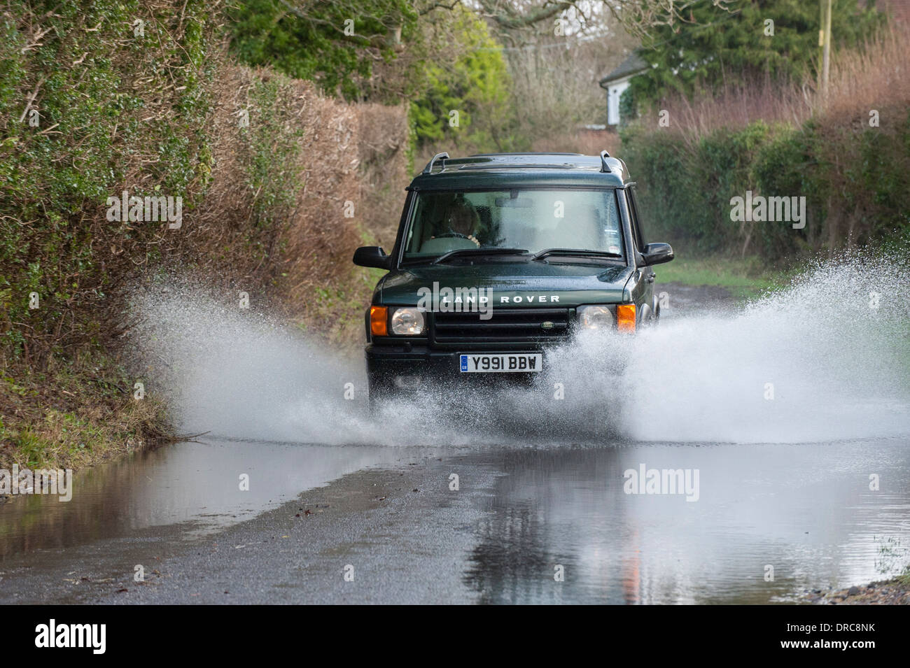Land Rover Discovery 4x4 driving through flood water on a country lane ...