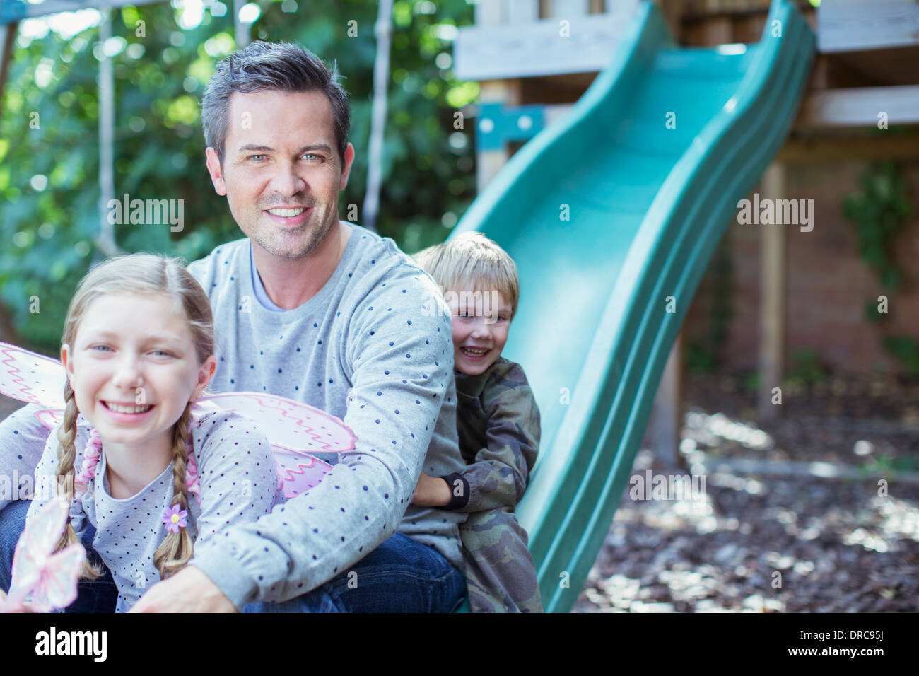 Father and children playing on play structure Stock Photo - Alamy