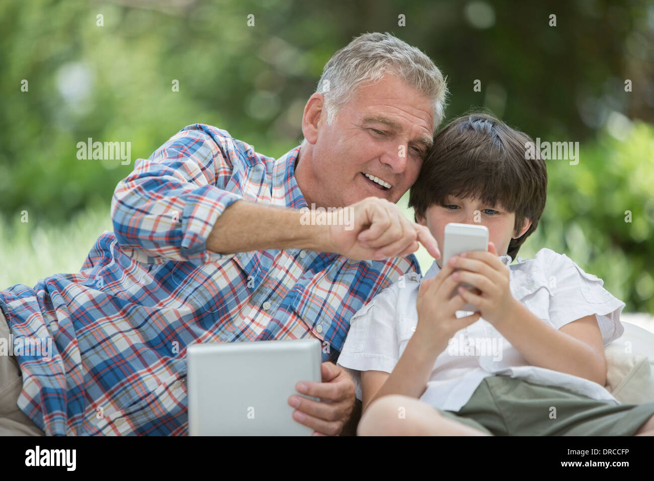 Grandpa grandson using mobile phone hi-res stock photography and images ...