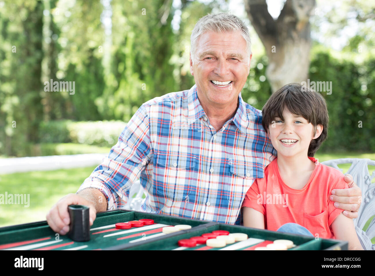 Grandfather and grandson playing backgammon on patio Stock Photo - Alamy