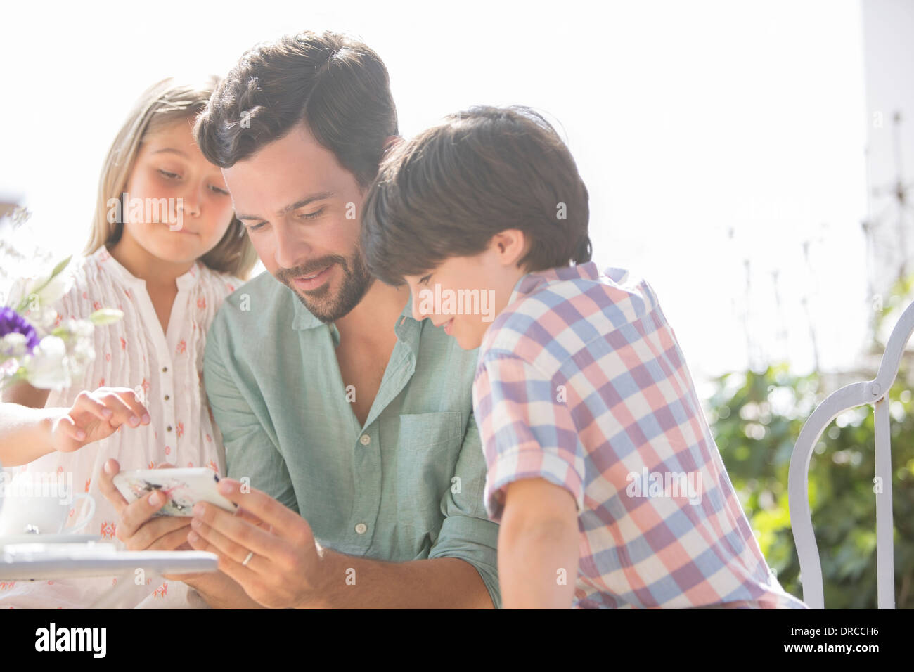 Father and children using cell phone outdoors Stock Photo - Alamy