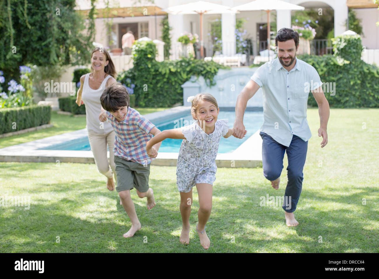 Family running together in backyard Stock Photo - Alamy