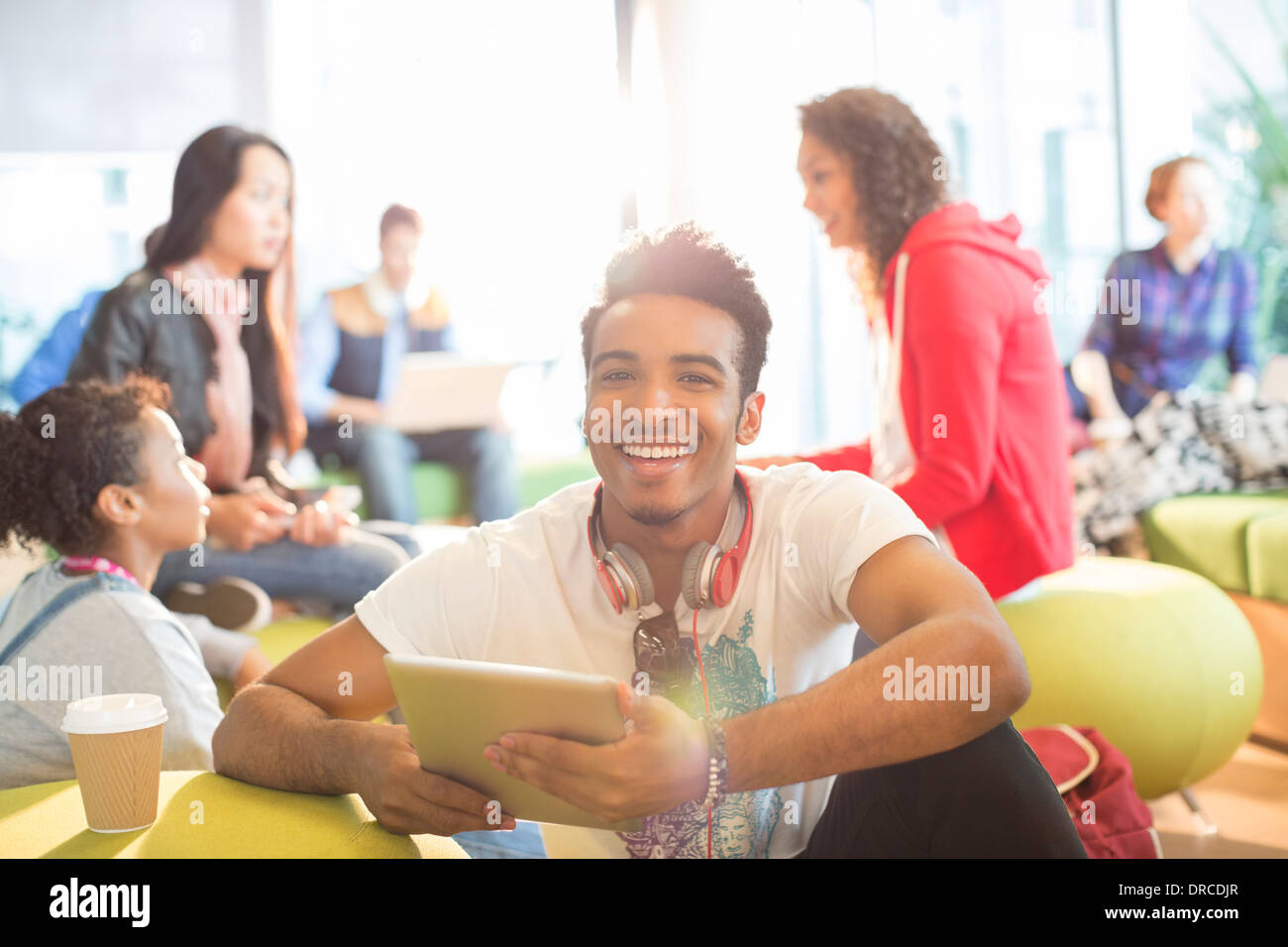 University student using digital tablet in lounge Stock Photo - Alamy