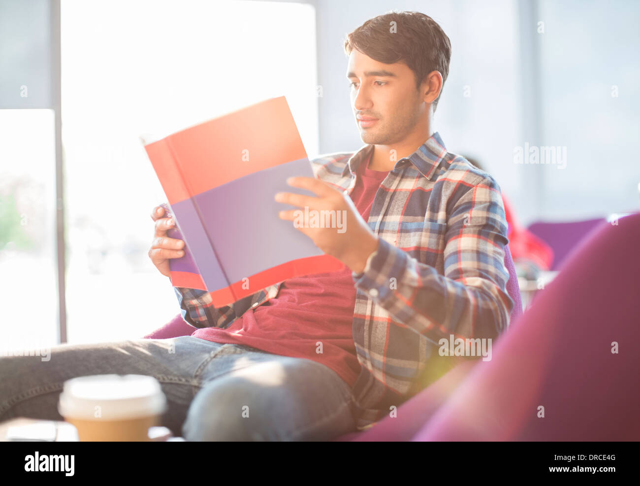 Student reading textbook in cafe Stock Photo - Alamy