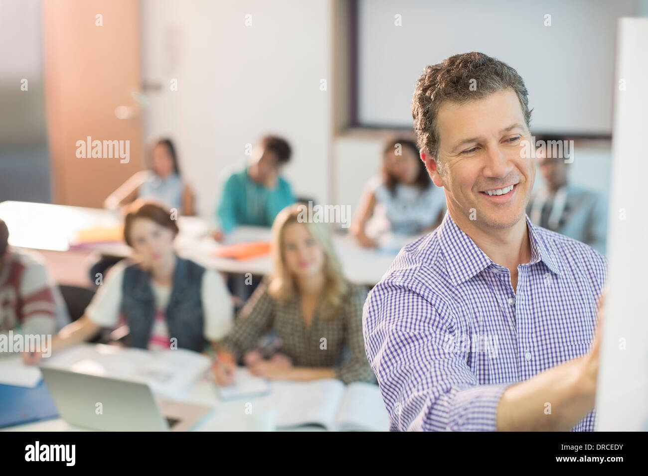 Professor writing on whiteboard in classroom Stock Photo - Alamy