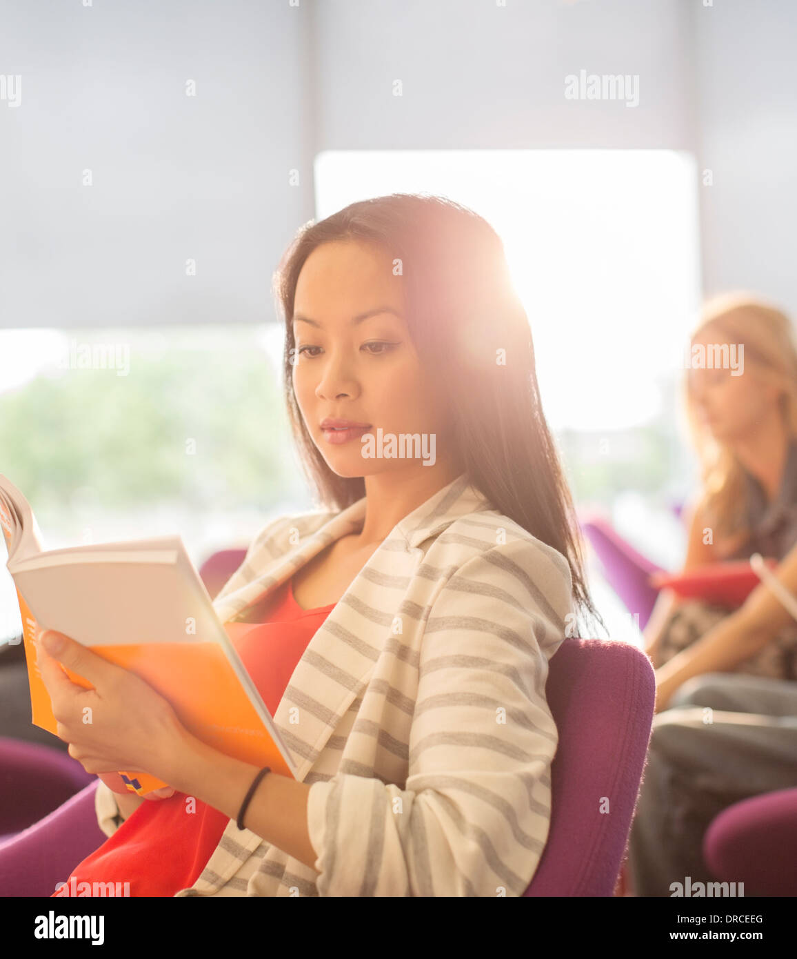University student reading in lounge Stock Photo - Alamy