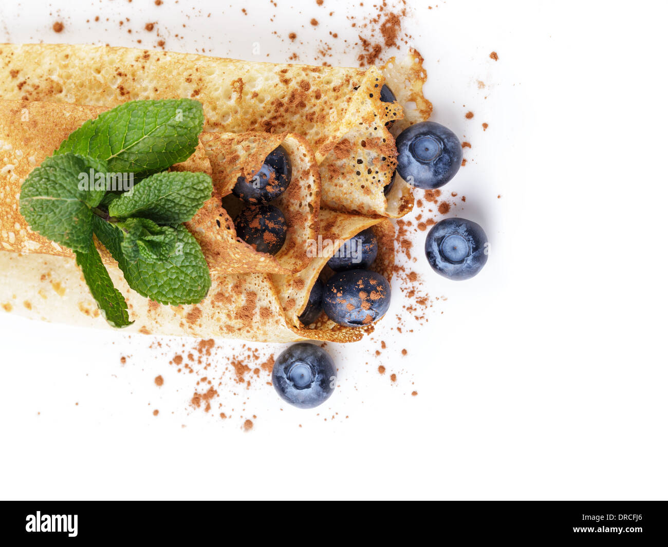 homemade blinis or crepes with blueberries and jam, on white background ...
