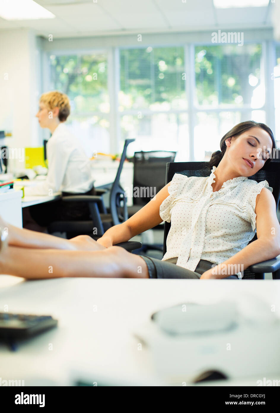 Businesswoman napping at desk in office Stock Photo - Alamy