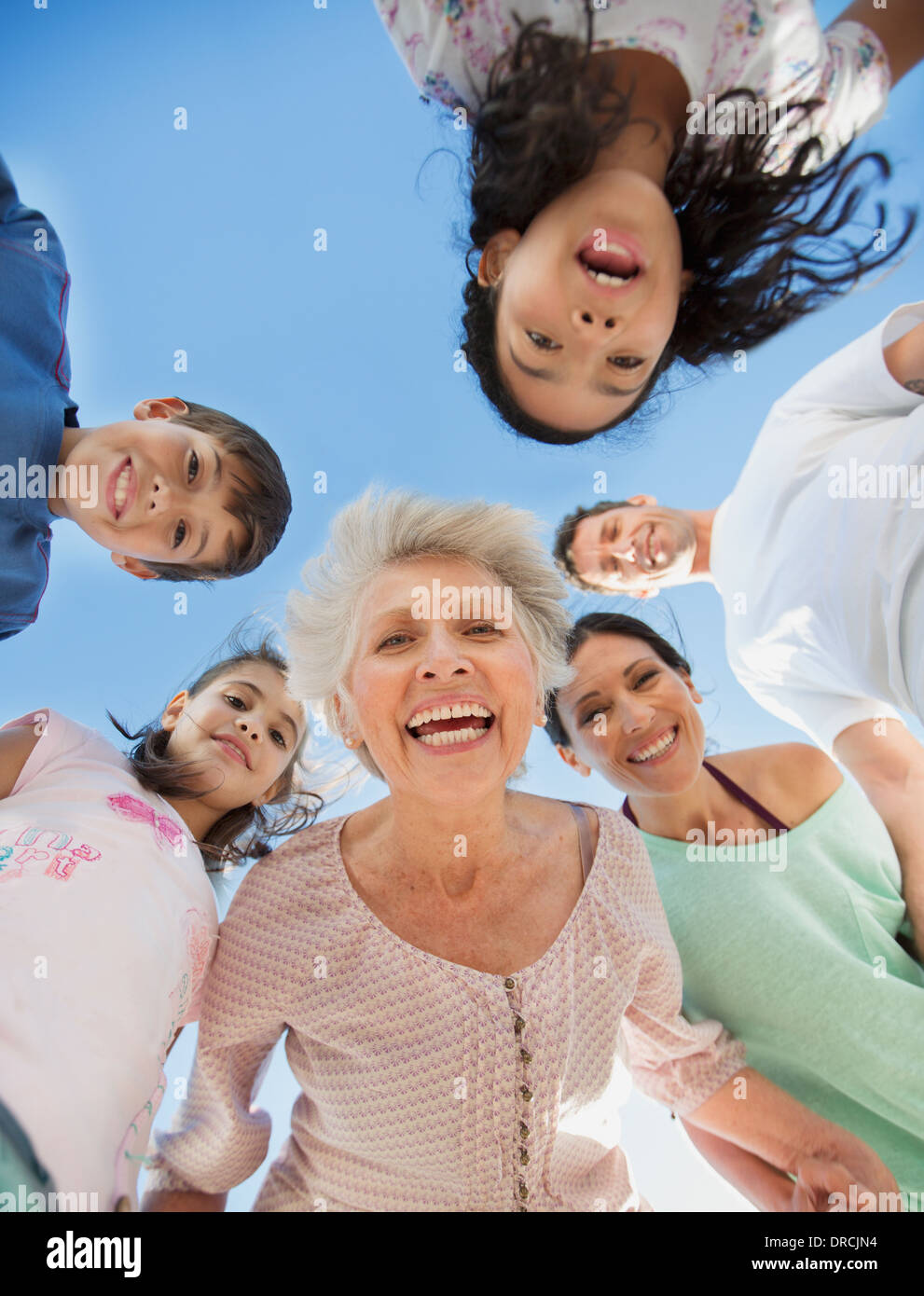 Multi-generation family smiling in huddle Stock Photo - Alamy