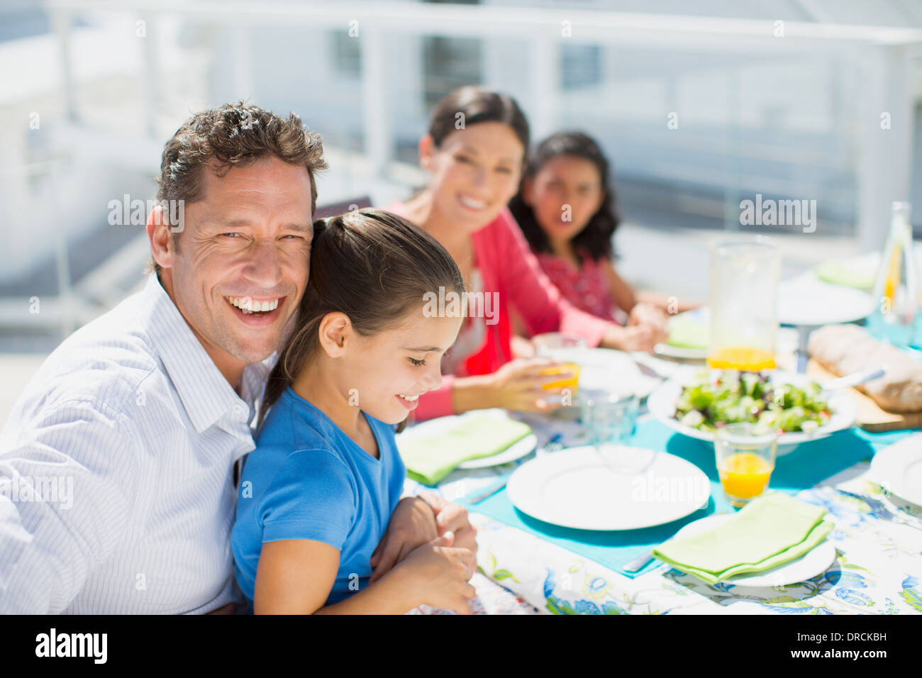 Family eating lunch at table on sunny patio Stock Photo - Alamy