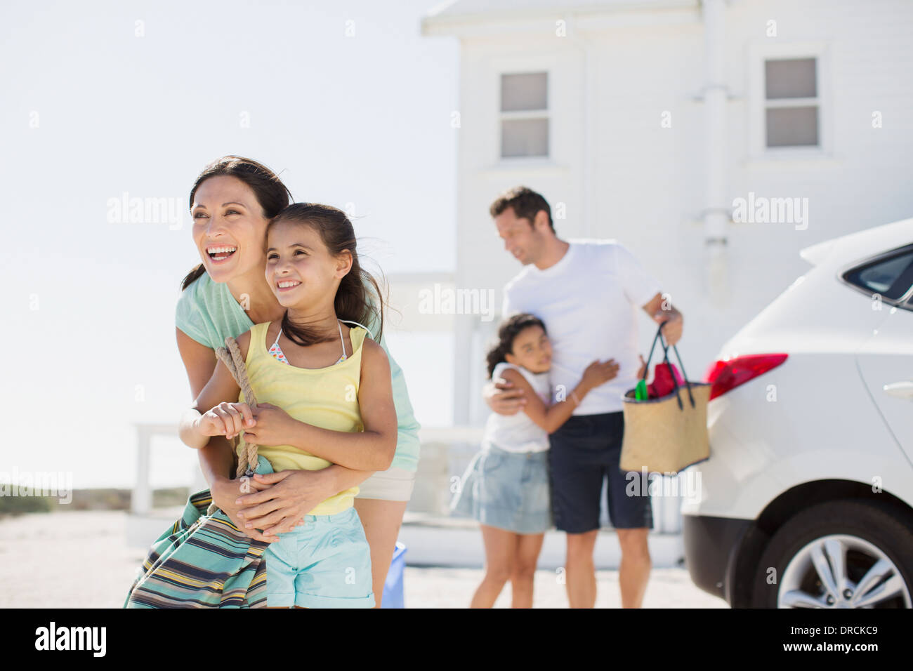 Family hugging in sunny driveway Stock Photo - Alamy