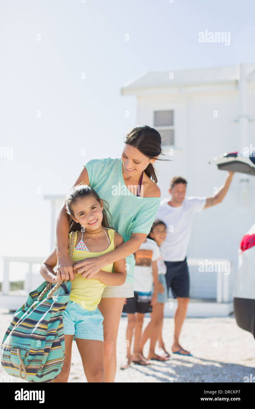 Mother and daughter hugging in sunny driveway Stock Photo - Alamy