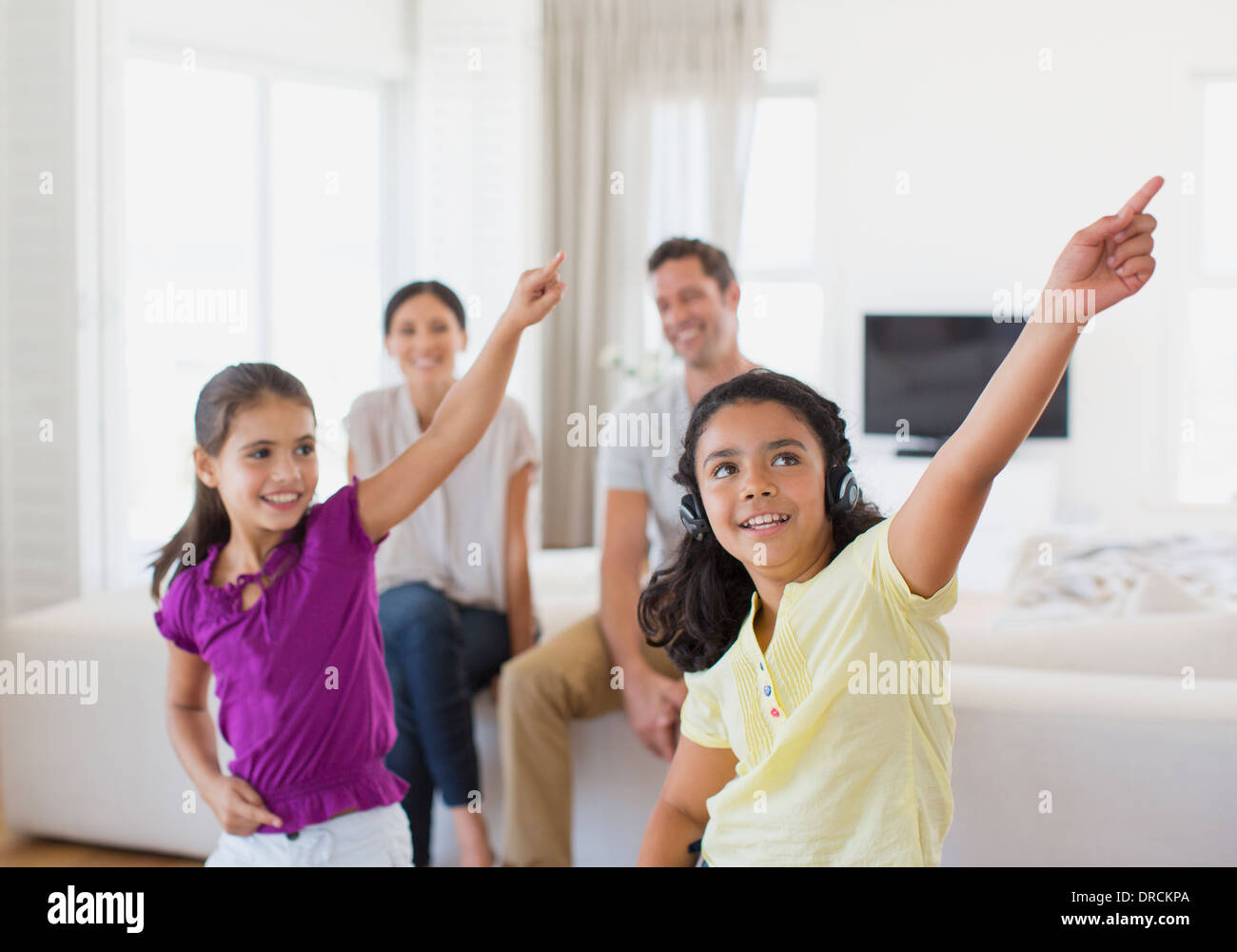Parents watching daughters dance in living room Stock Photo - Alamy