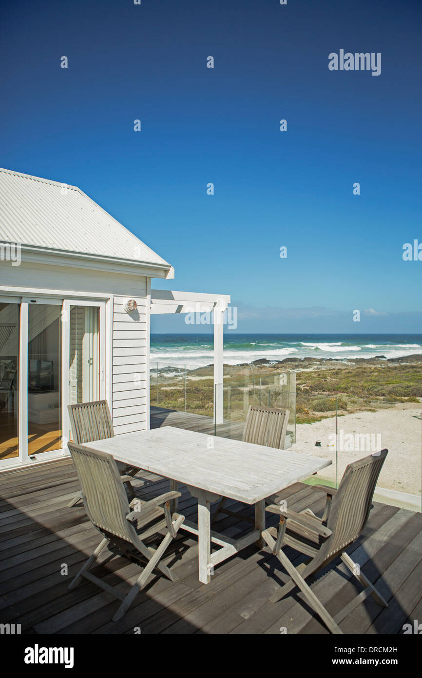 Table and chairs on patio overlooking beach Stock Photo - Alamy
