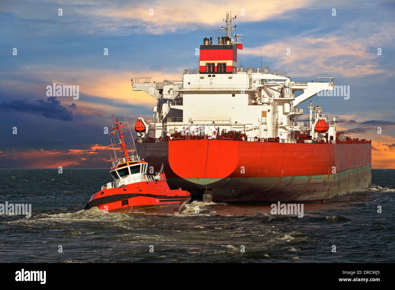 Tug boat towing a tanker ship at sea Stock Photo - Alamy