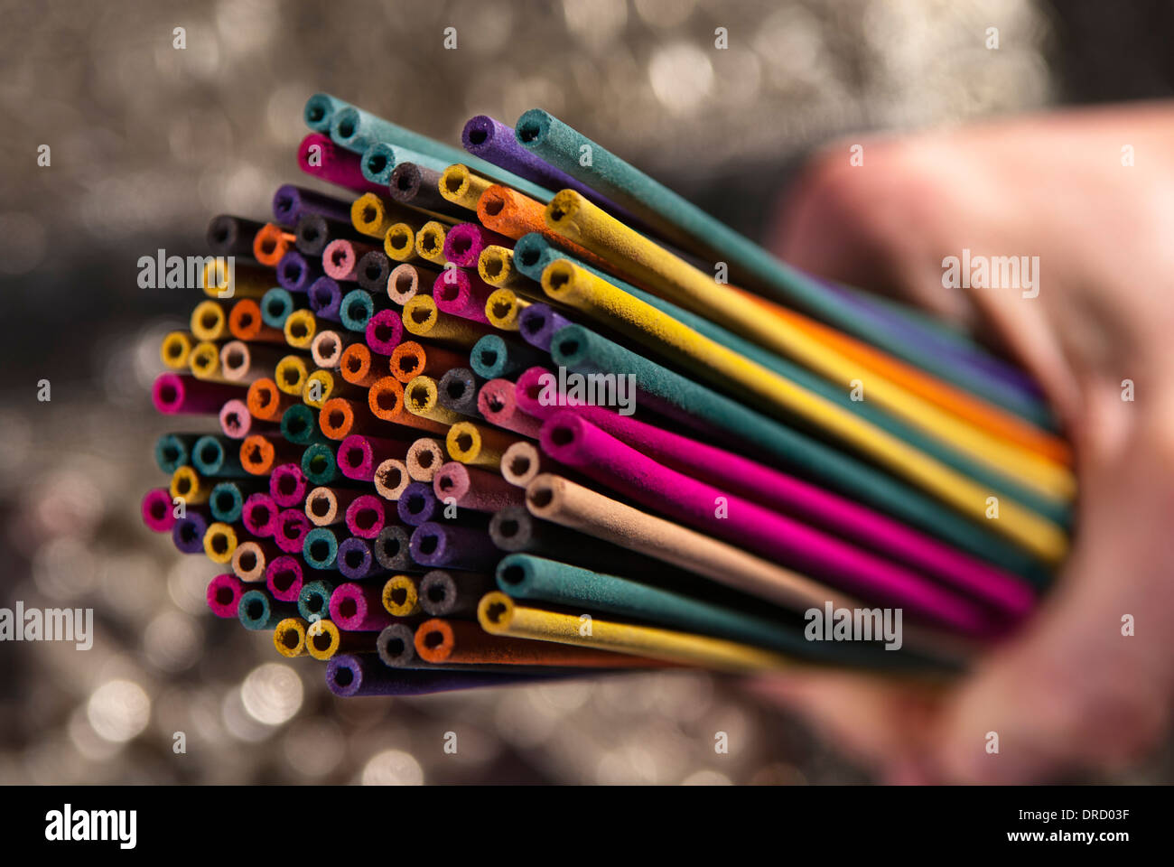 Artistic group of colourful incense sticks held in hand Stock Photo - Alamy