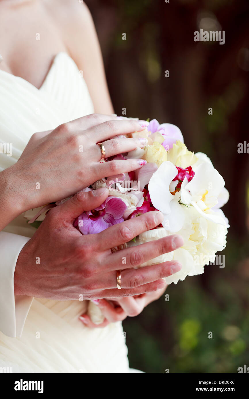 Bride and groom hands on the wedding posy Stock Photo - Alamy