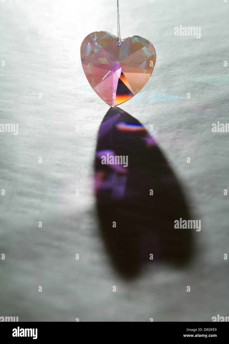 A heart shaped prism casts a shadow on a white background Stock Photo ...