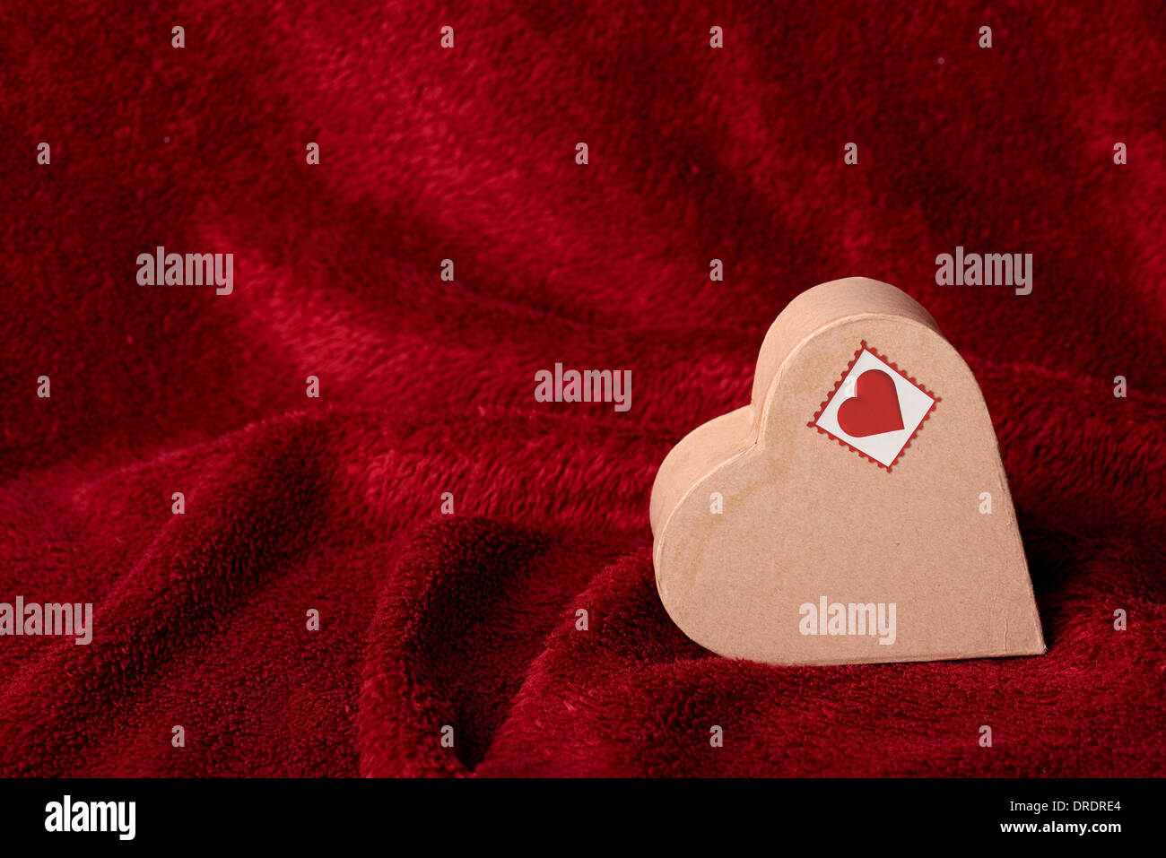 A brown cardboard heart box on a red textured background Stock Photo ...