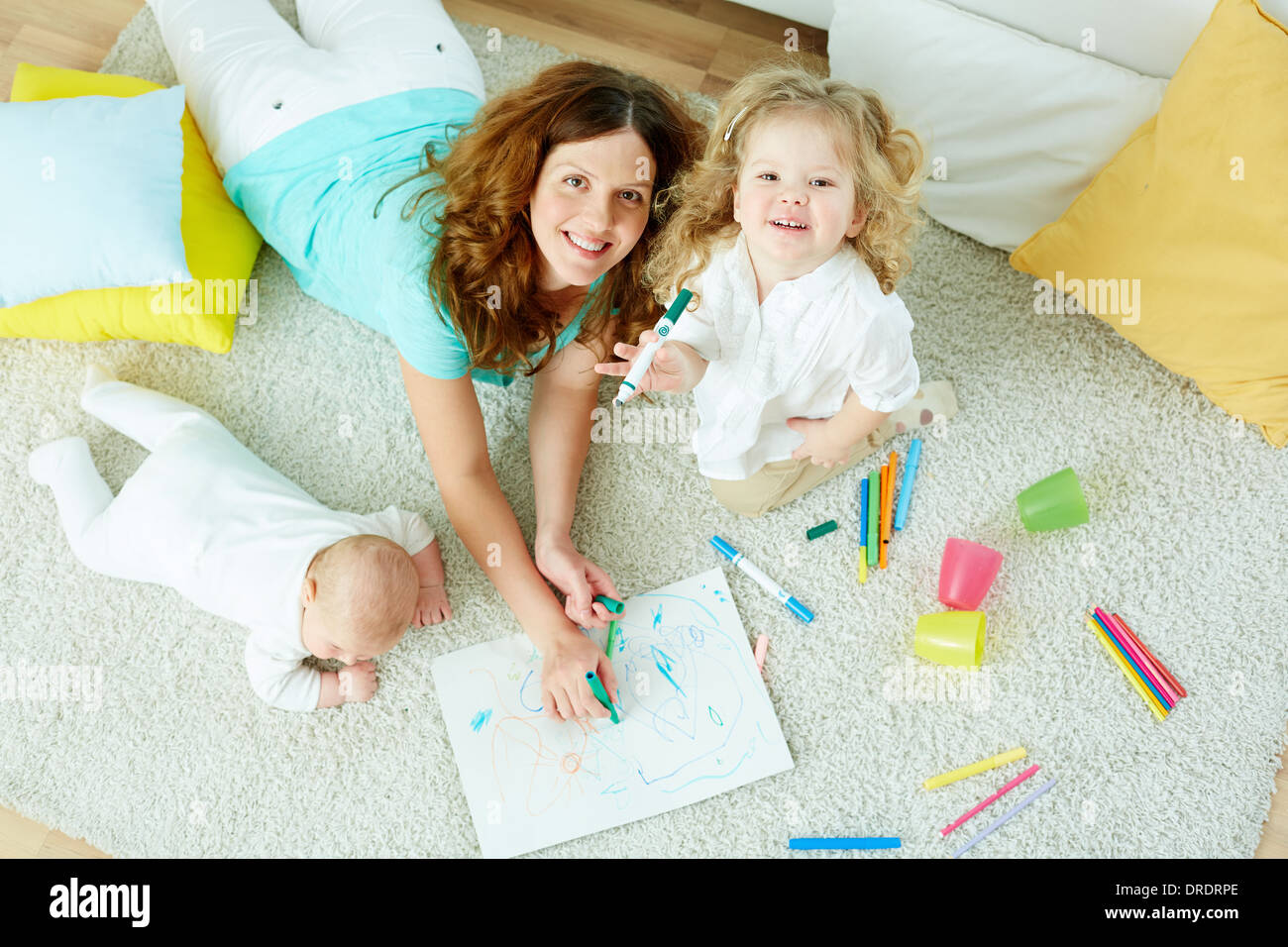 The above-view portrait of a beautiful babysitter looking after cute ...