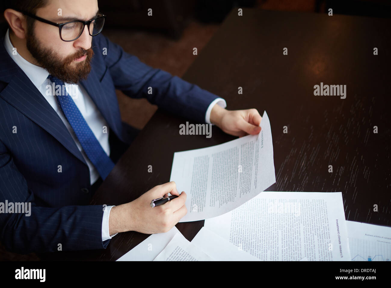 Image of serious businessman signing contract at workplace Stock Photo ...