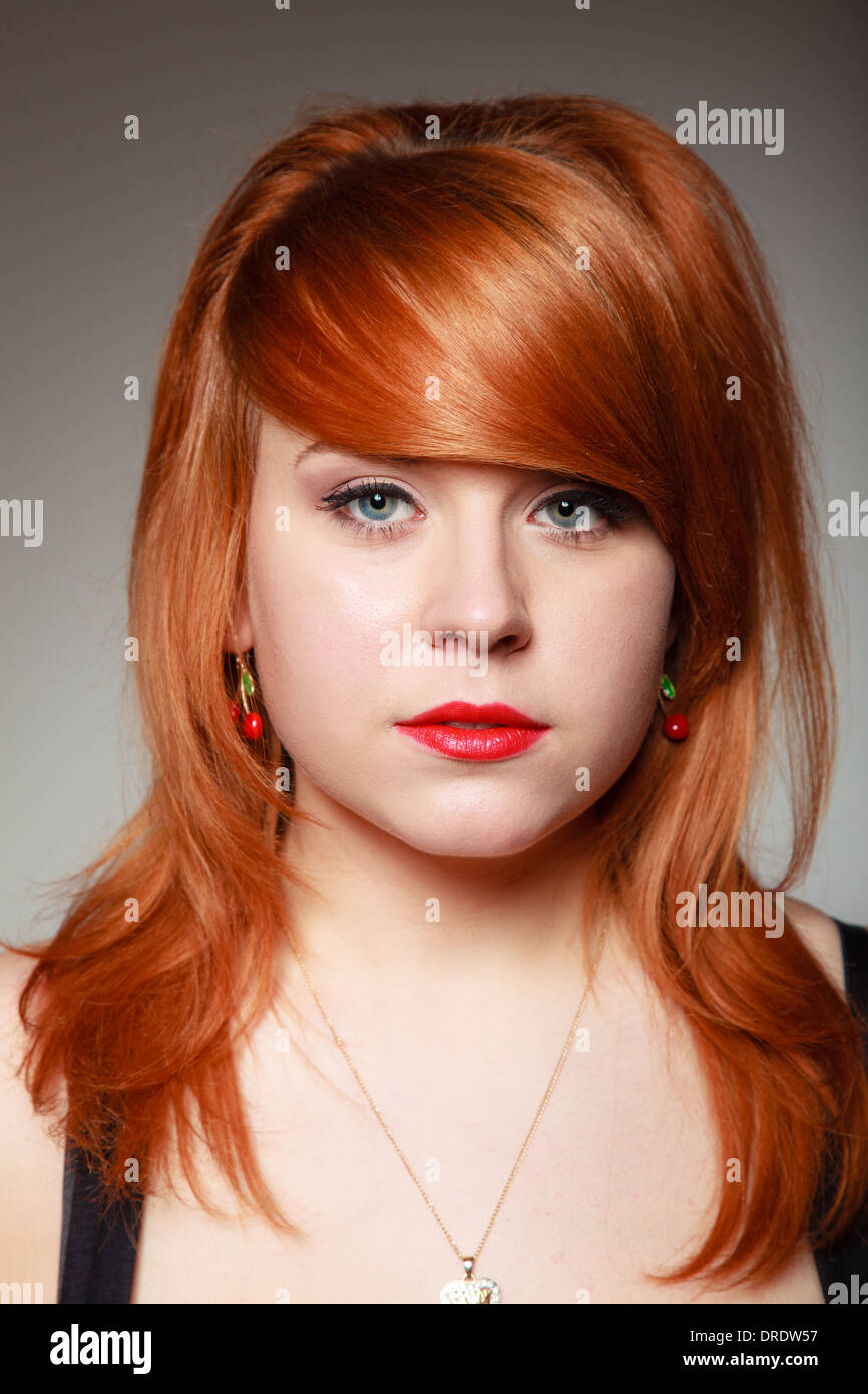 Portrait redhaired girl young woman with cherry earing on gray Stock ...