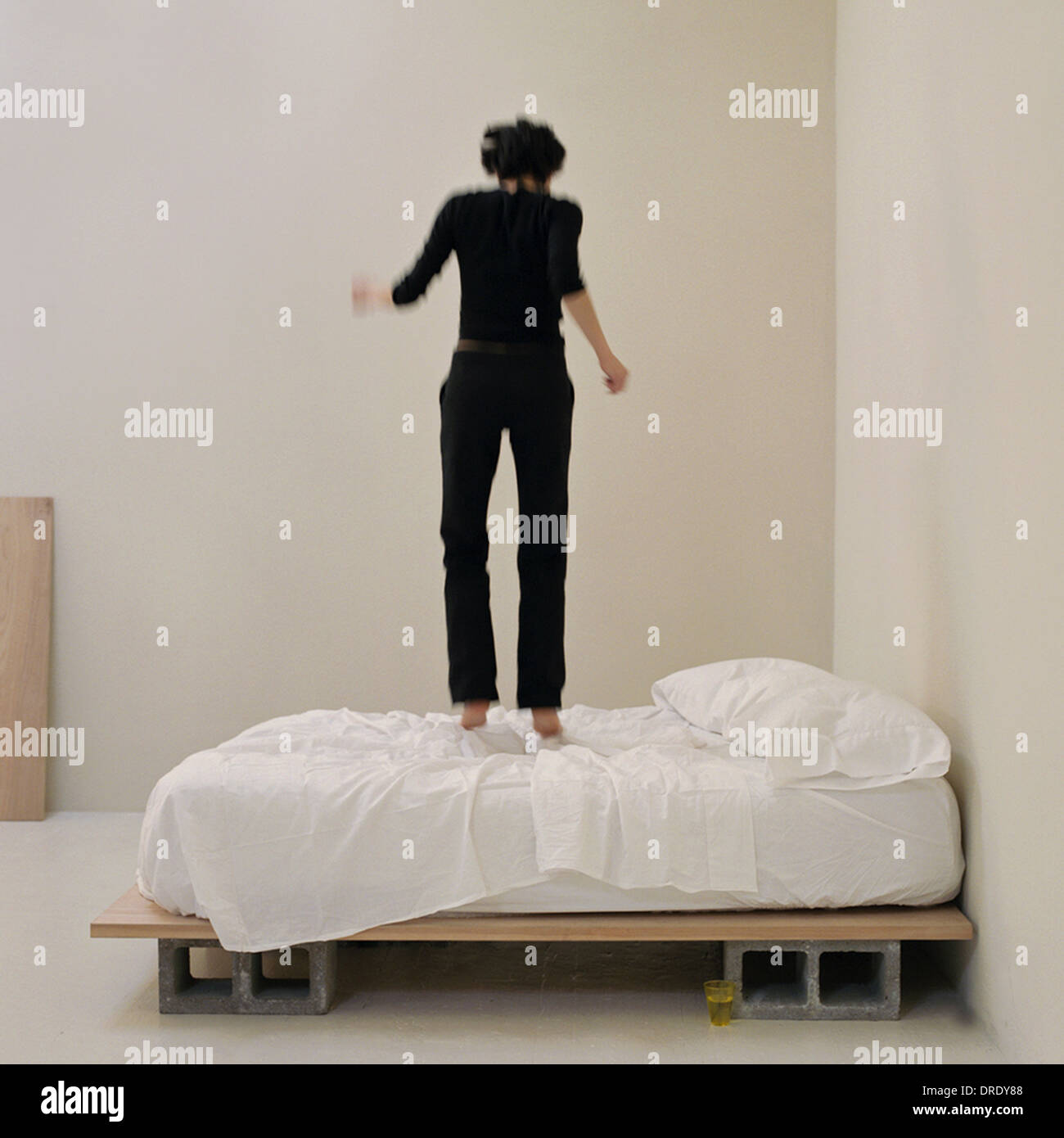 Woman jumping on bed Stock Photo - Alamy