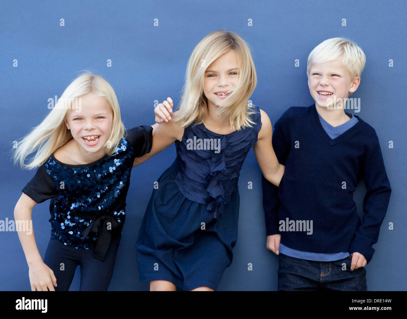 Portrait of siblings in front of blue background Stock Photo - Alamy