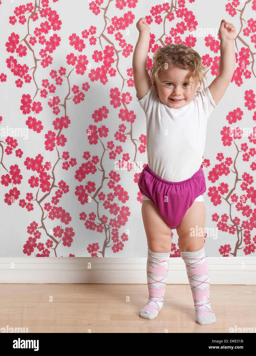 Toddler in front of colorful wall paper Stock Photo - Alamy