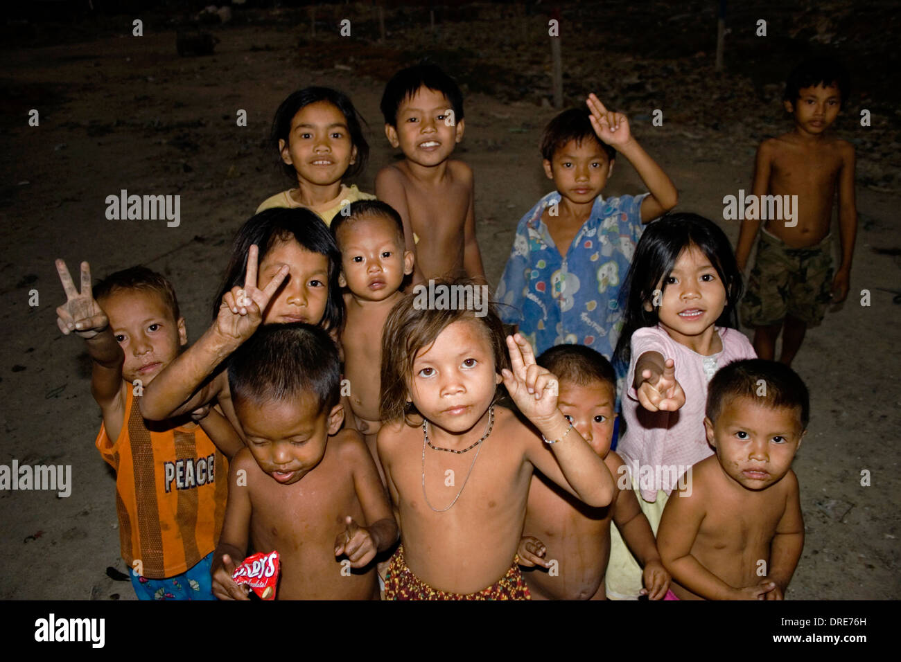A group of young childern are gathered together near homes adjacent to ...