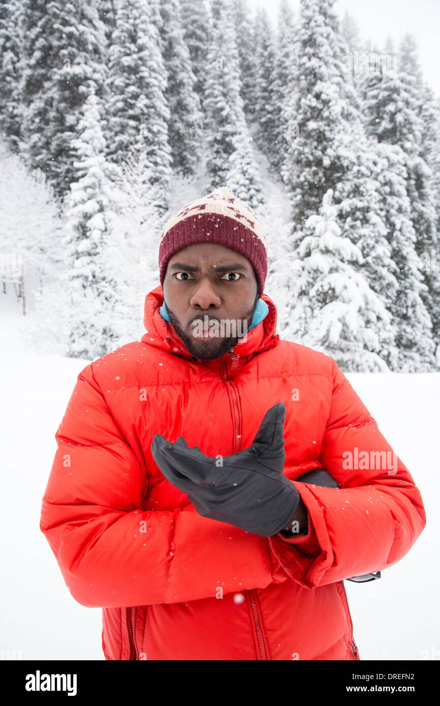 African American Cheerful black man in ski suit in snowy winter ...