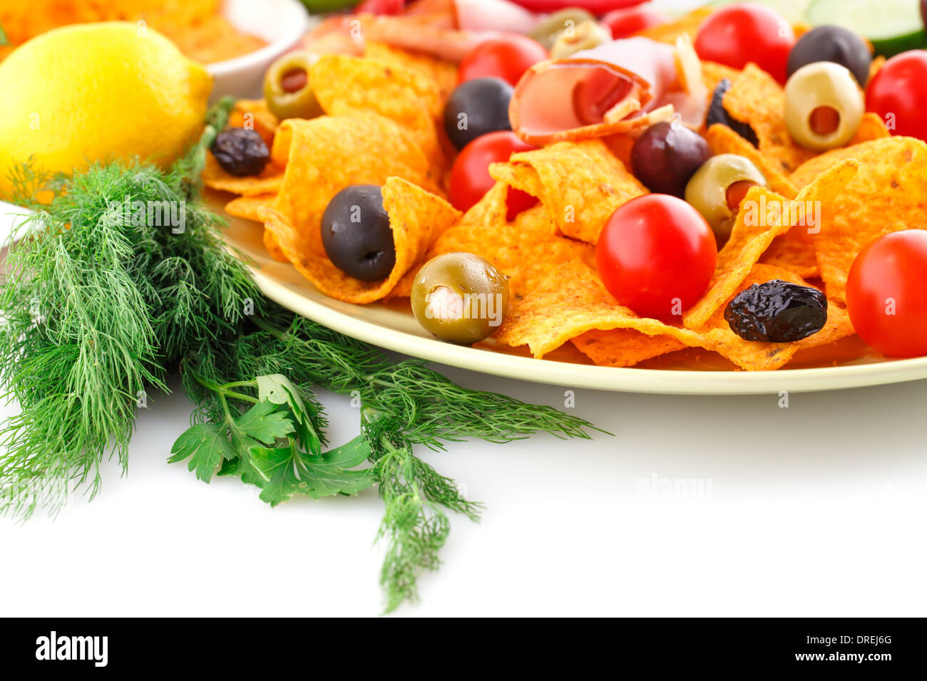 Nachos, olives, pork loin and vegetables image Stock Photo - Alamy