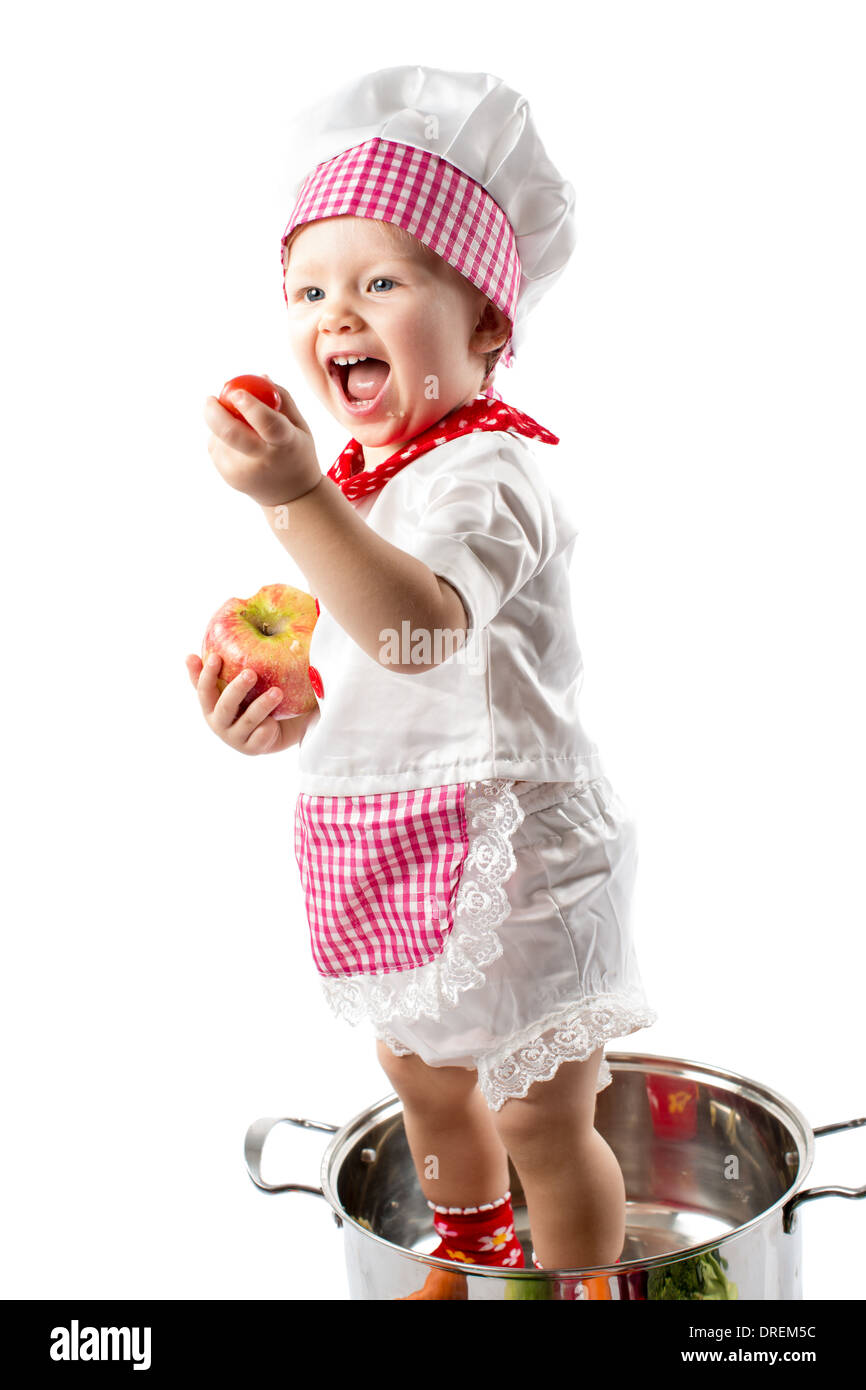 Baby cook girl wearing chef hat with fresh vegetables and fruits. Use ...